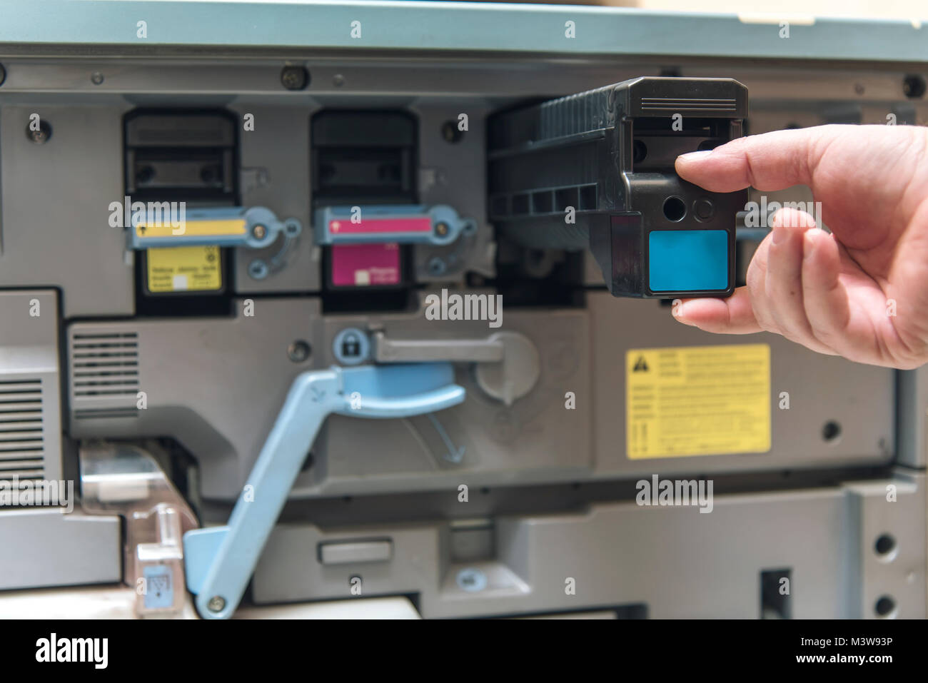 Young man replacing color toner inside a copier Stock Photo - Alamy