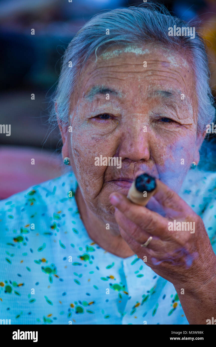 Woman smoking a cheroot cigar in market in bagan, Myanmar Stock Photo ...