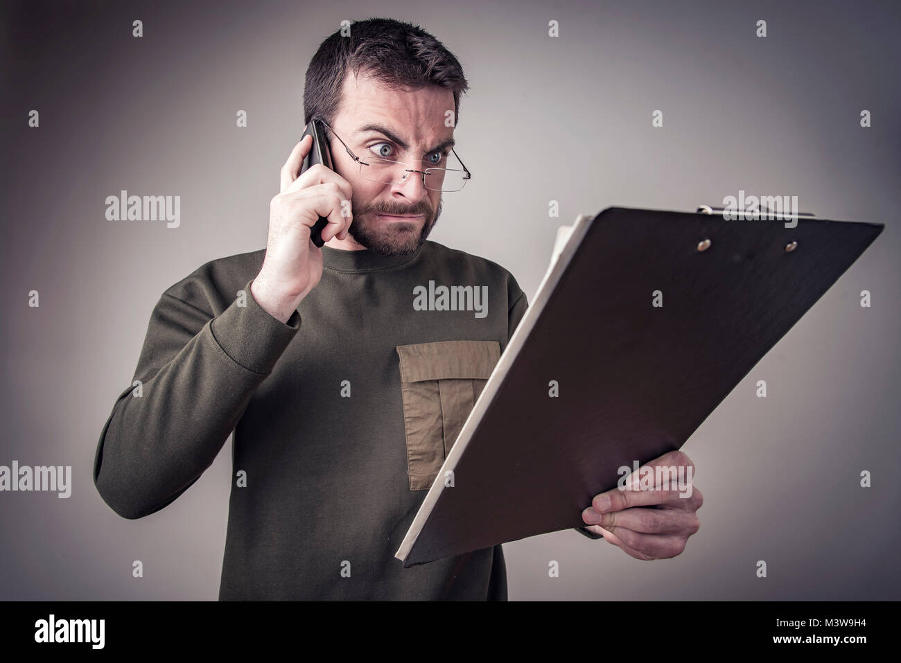 Bad or wrong invoice, young man yelling at his phone Stock Photo - Alamy