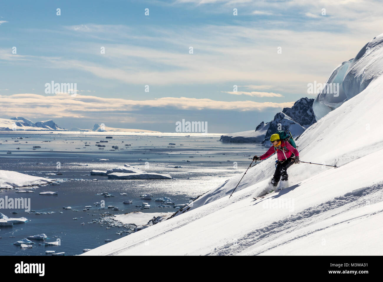 Female alpine ski mountaineer skiing downhill in Antarctica; Rongé ...