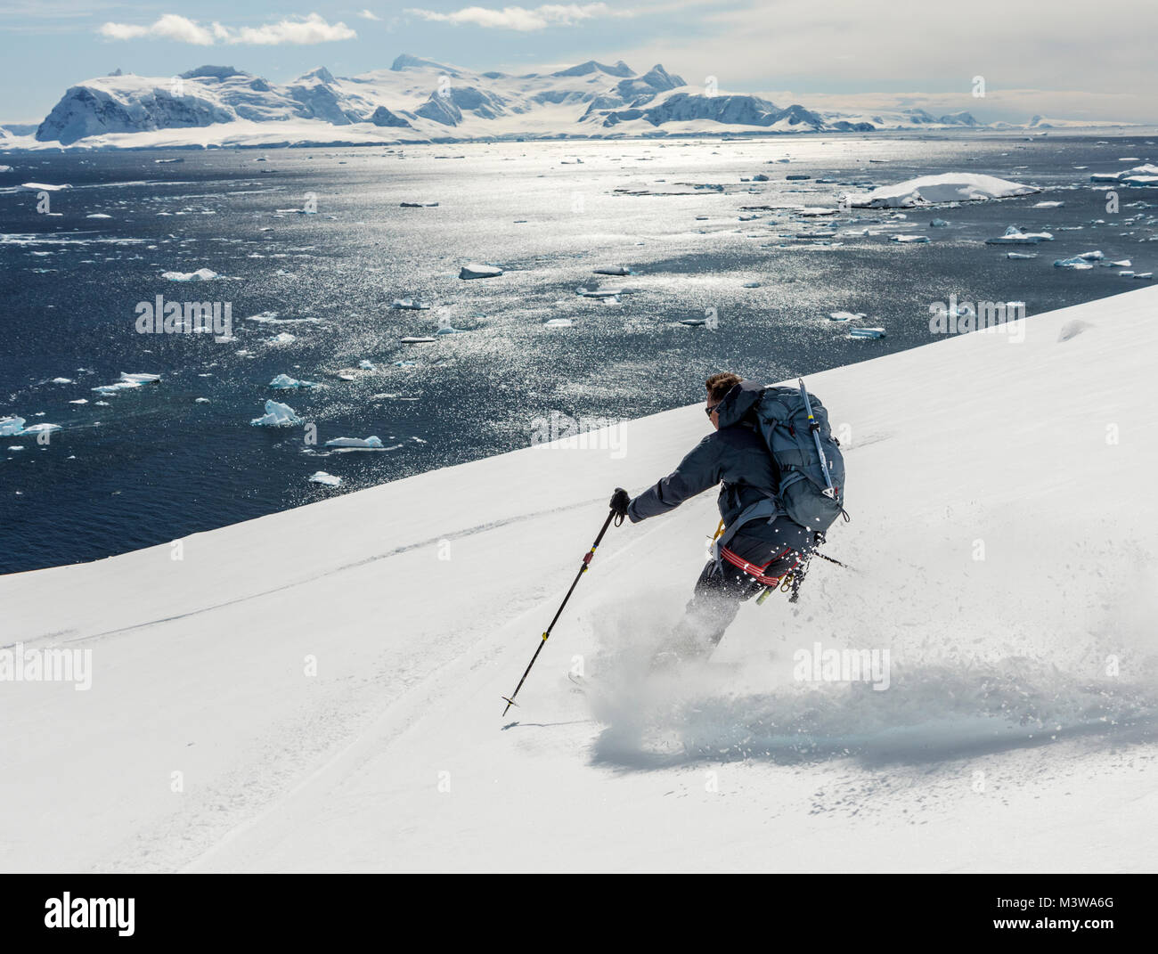 Alpine ski mountaineer skiing downhill in Antarctica; Rongé Island ...