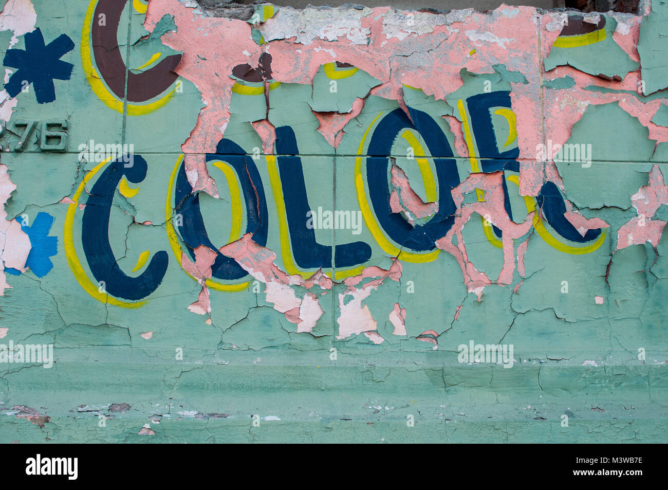 A chipped and peeling painted wall with the word color written on it ...
