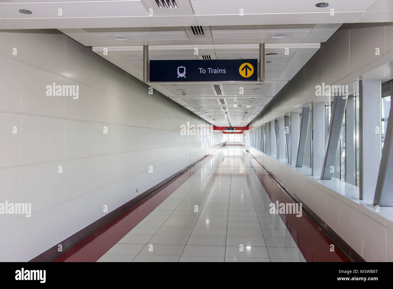 The empty corridor with signboard shows way to the train station. The ...