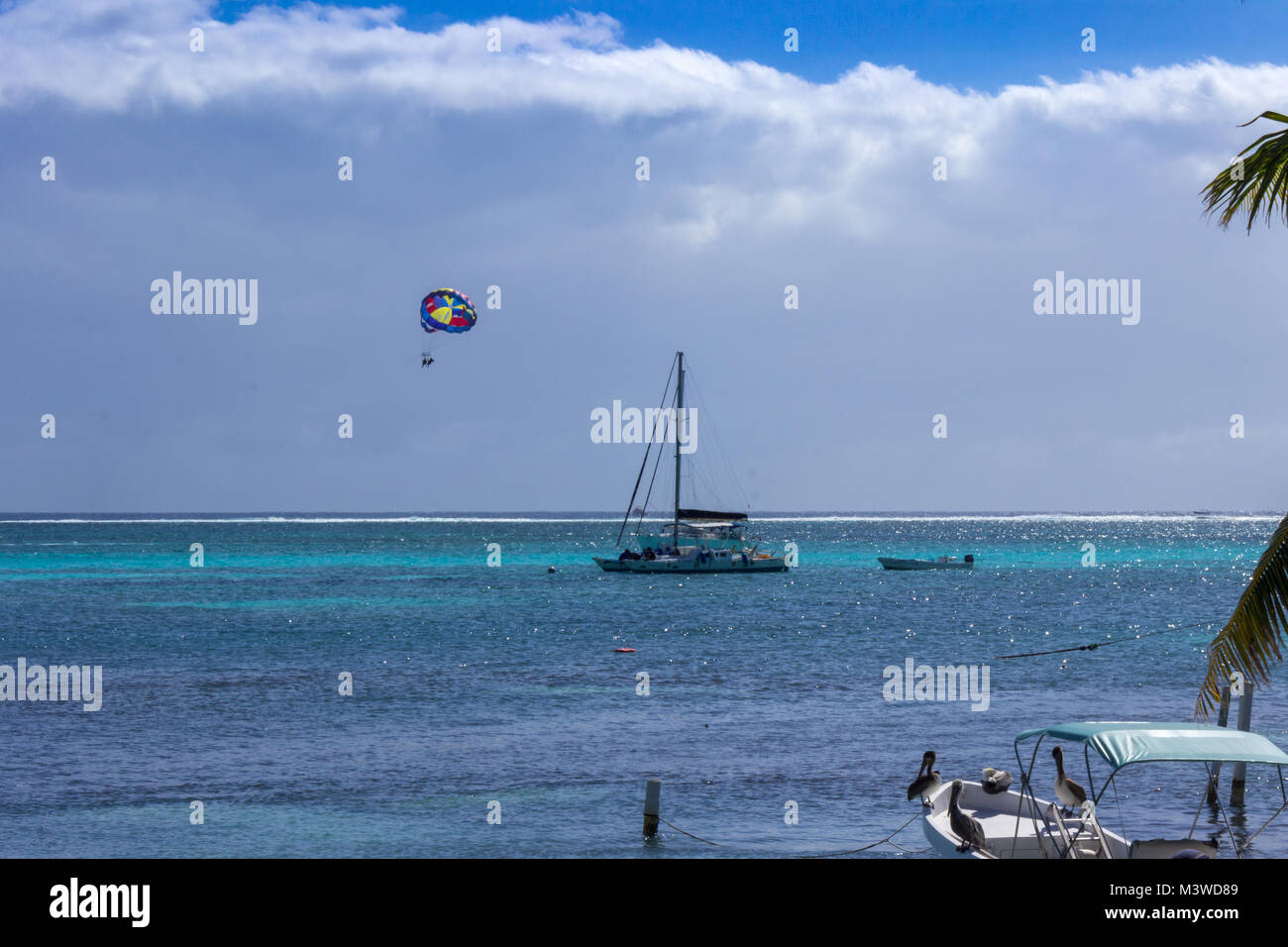 A parasail floats over the blue and azure waters of the Caribbean Sea ...