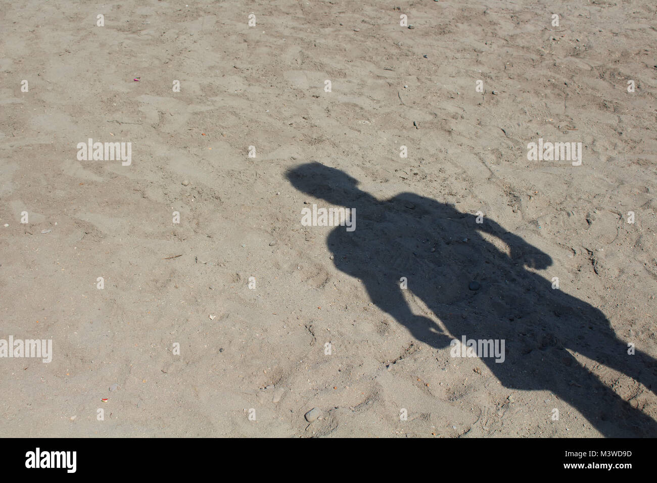 Shadow of man standing on sand background Stock Photo - Alamy