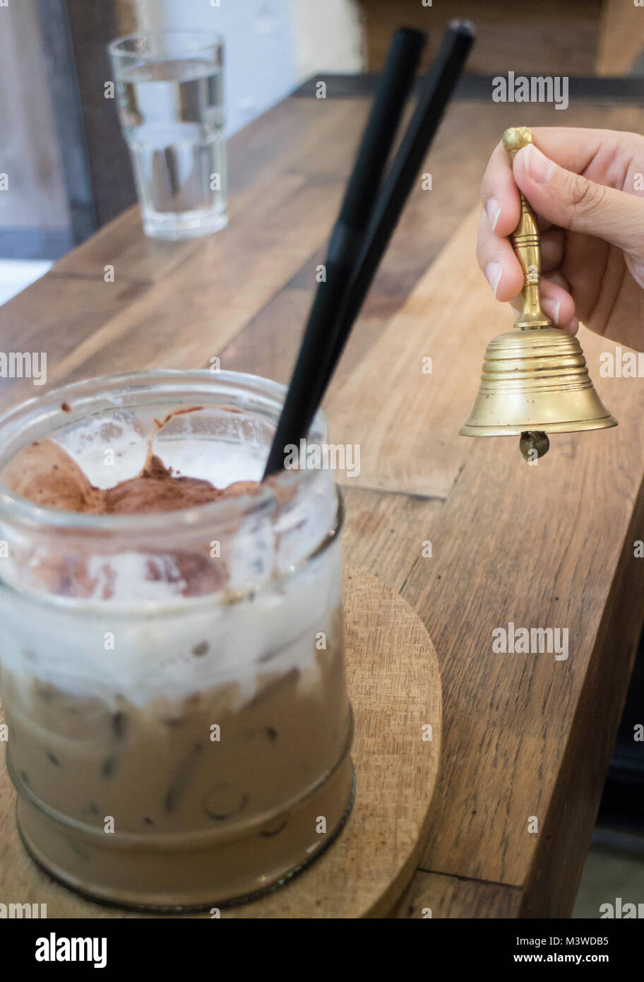 Hand on brass bell in coffee shop, stock photo Stock Photo - Alamy