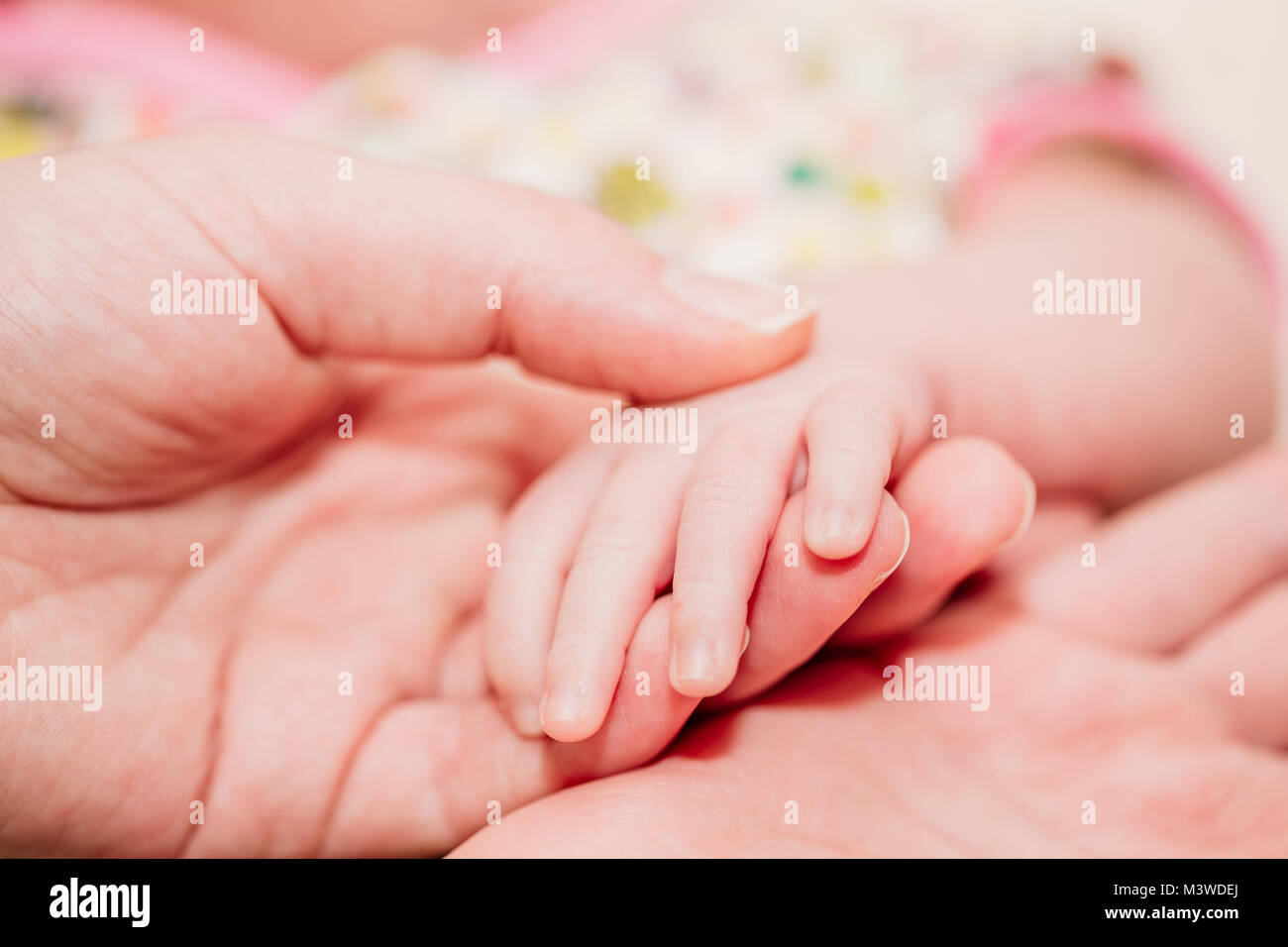 Baby handle close-up that holds mom's hand Stock Photo - Alamy