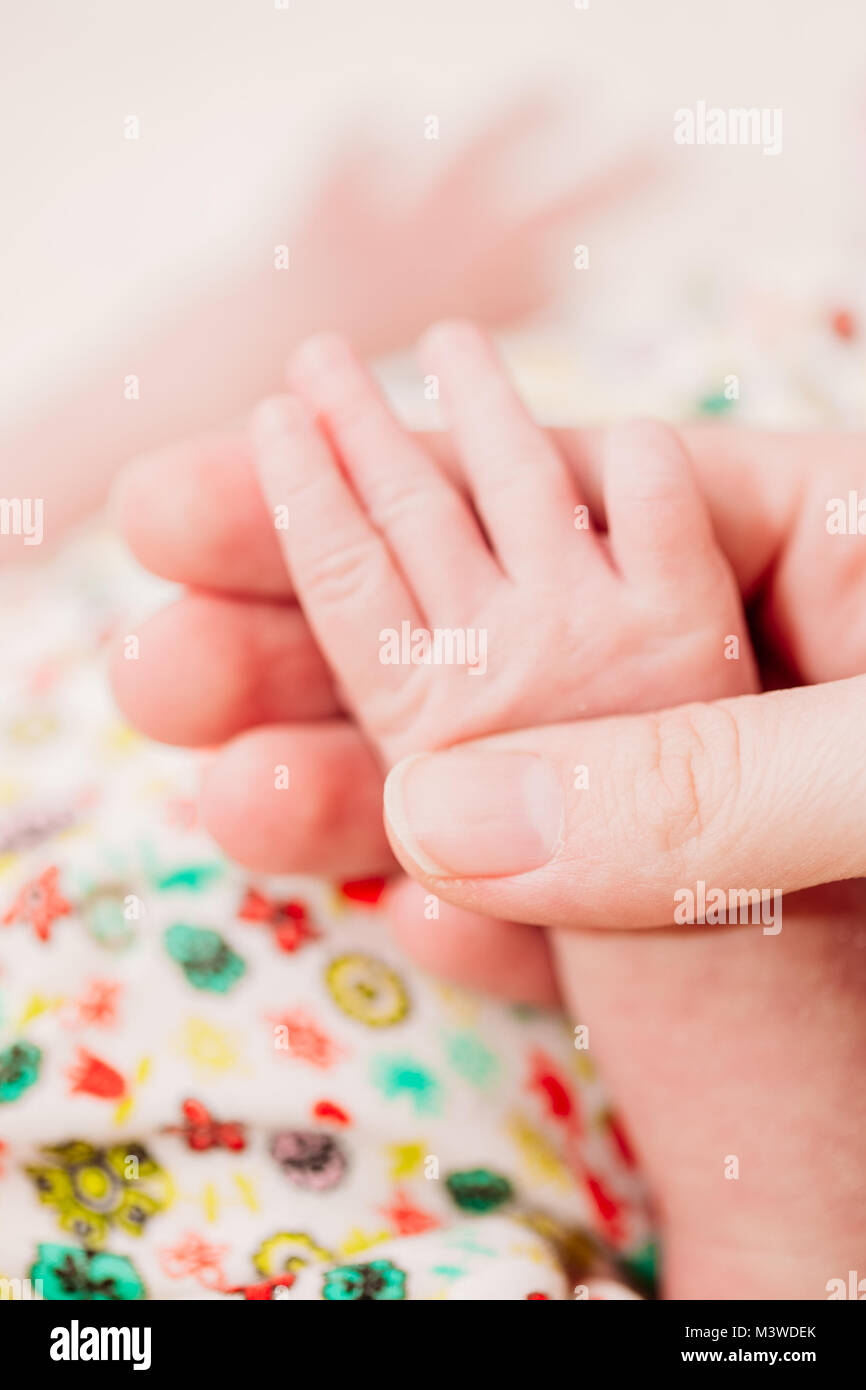 Handle baby in mom's hand in blur Stock Photo - Alamy