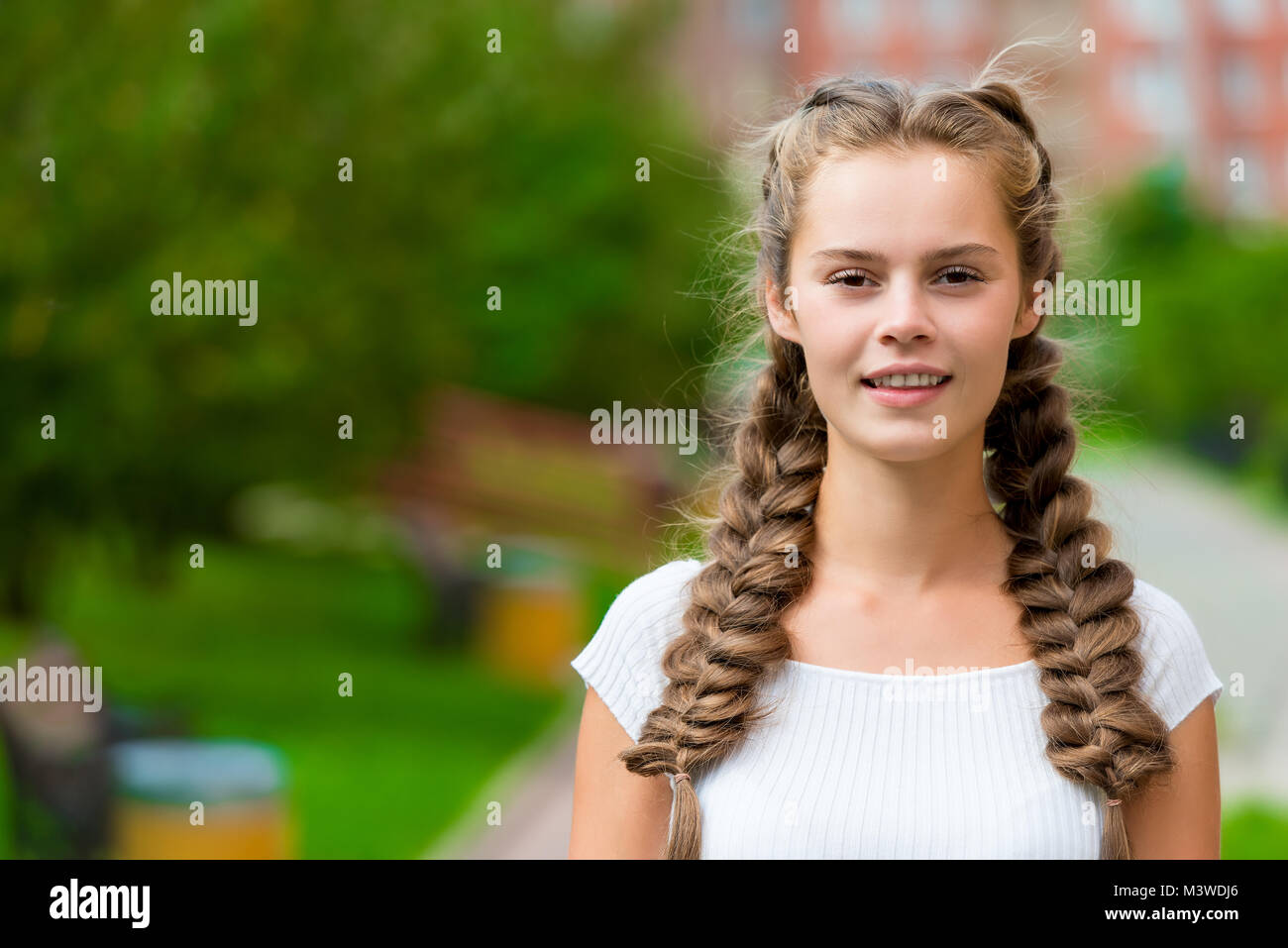 horizontal portrait of a beautiful young girl with two braids on the ...