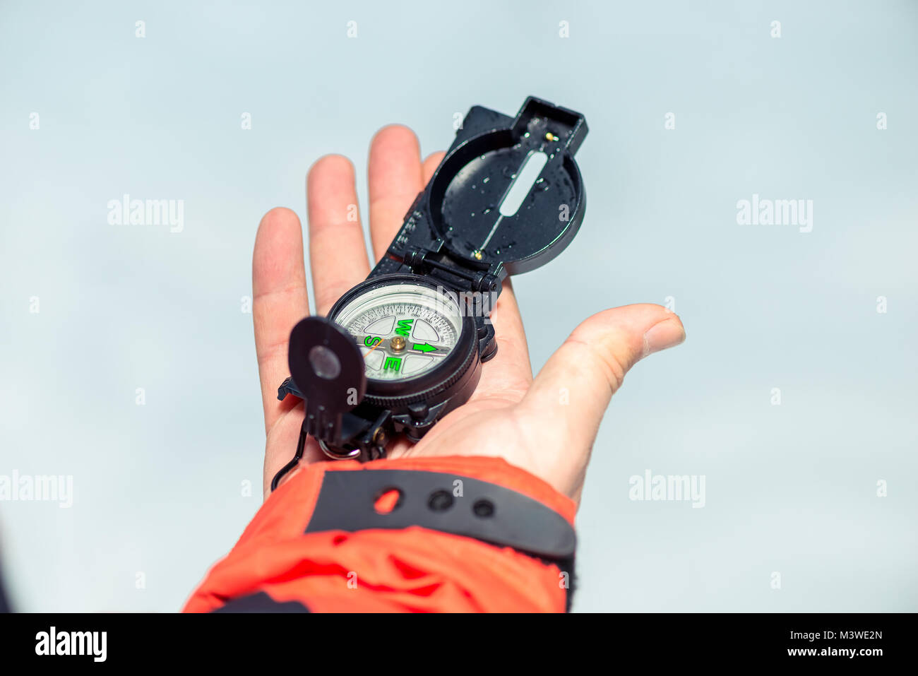 man's hand close-up with a compass on white snow background Stock Photo ...