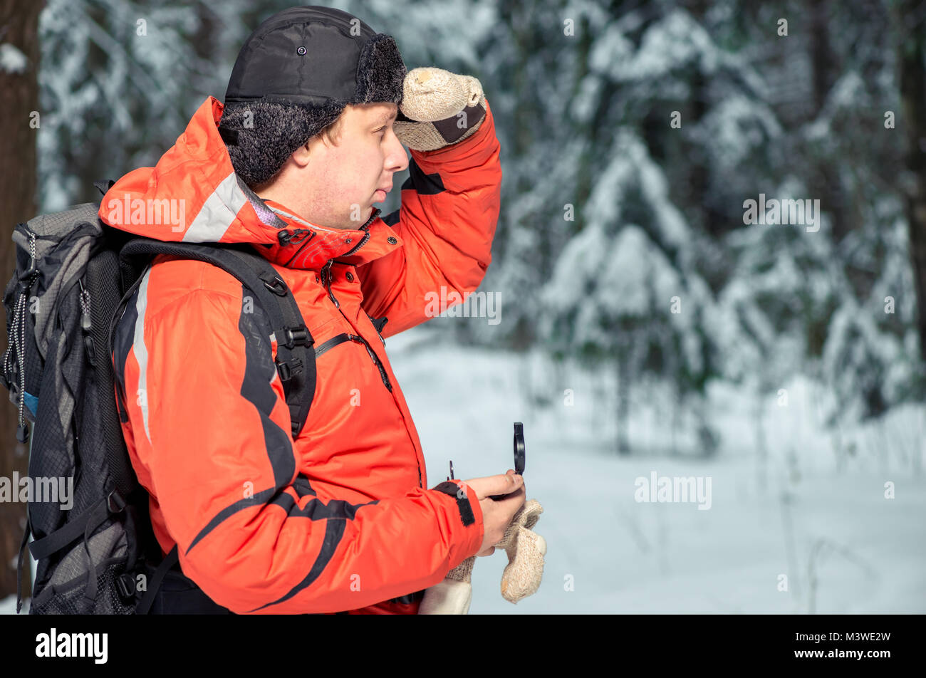 a man with a backpack and a compass got lost in a snowy forest Stock ...
