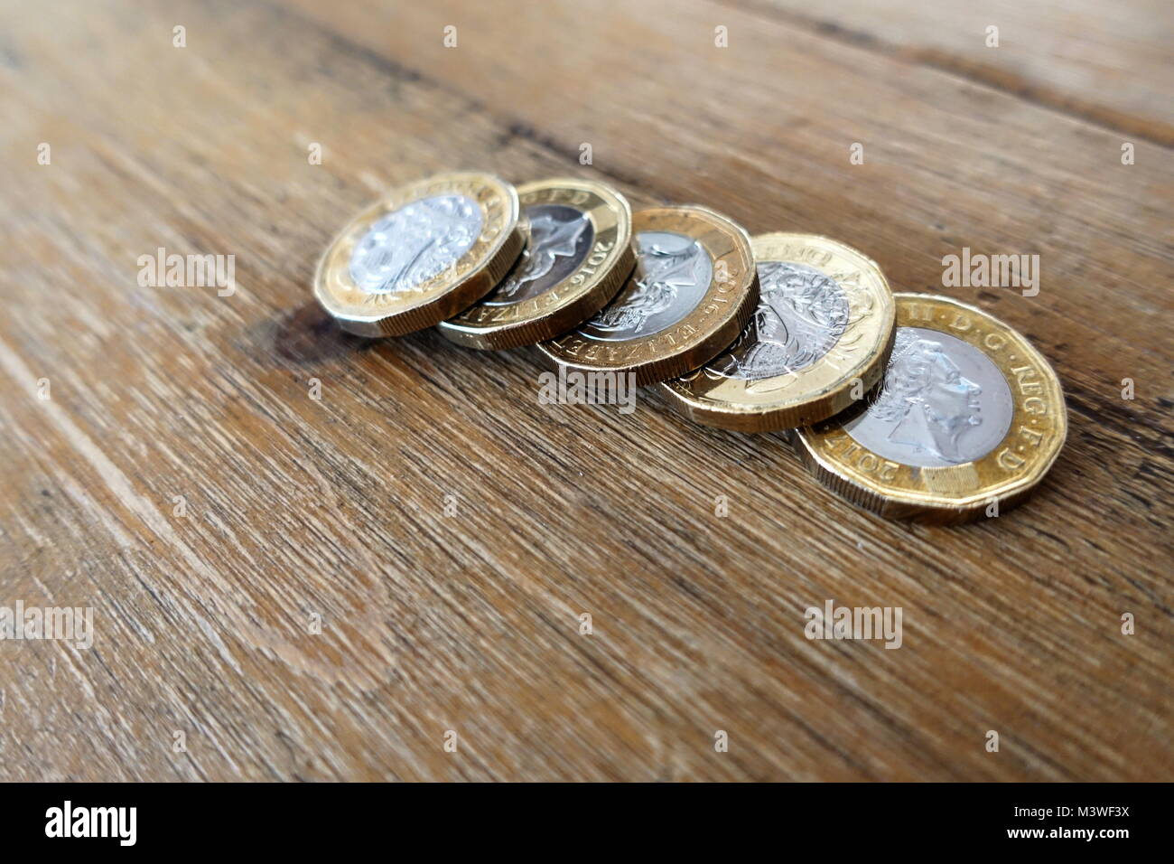 Five British UK pound coins on a wooden table Stock Photo - Alamy