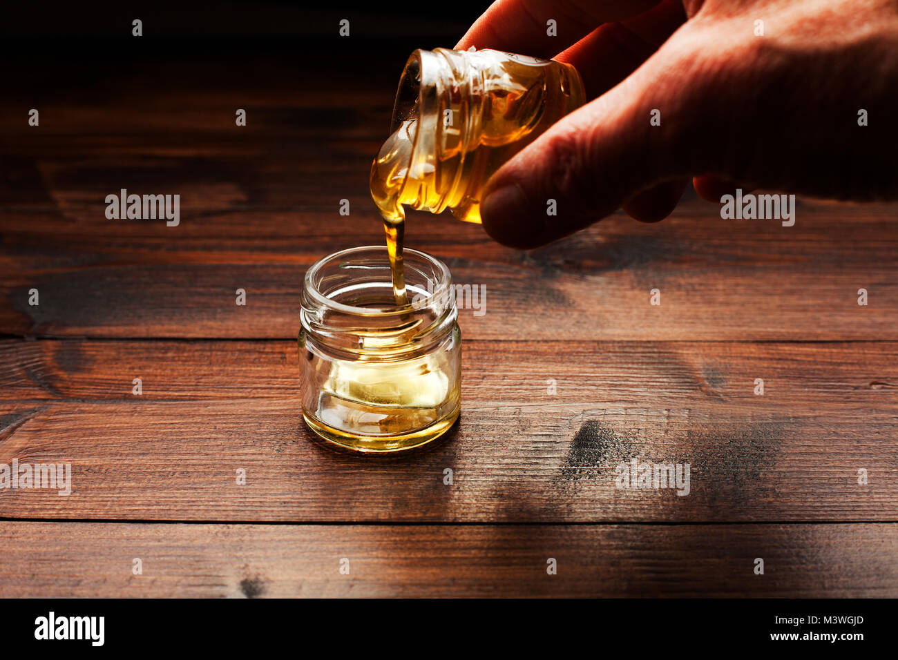 Bee farmer pours test samples of honey for customers Stock Photo - Alamy