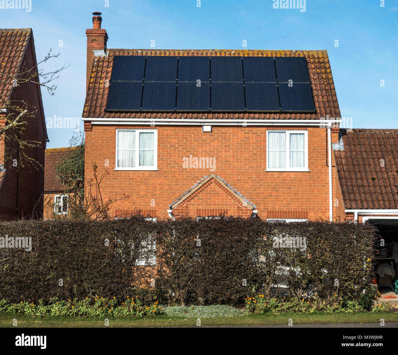 Solar panels in direct sunlight, attached to the pitched / sloping roof ...