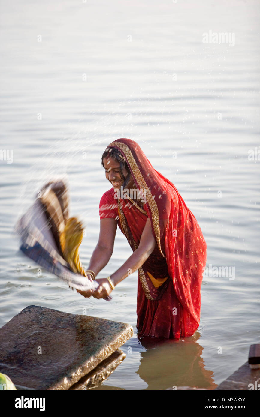 India. Varanasi (Benares). The ghats. Hindu woman washing clothes in ...