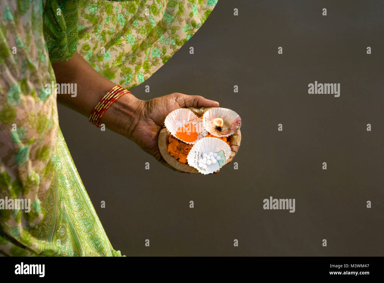 India, Varanasi, Ganga river, Ghats. Hindu pilgrim woman placing ...
