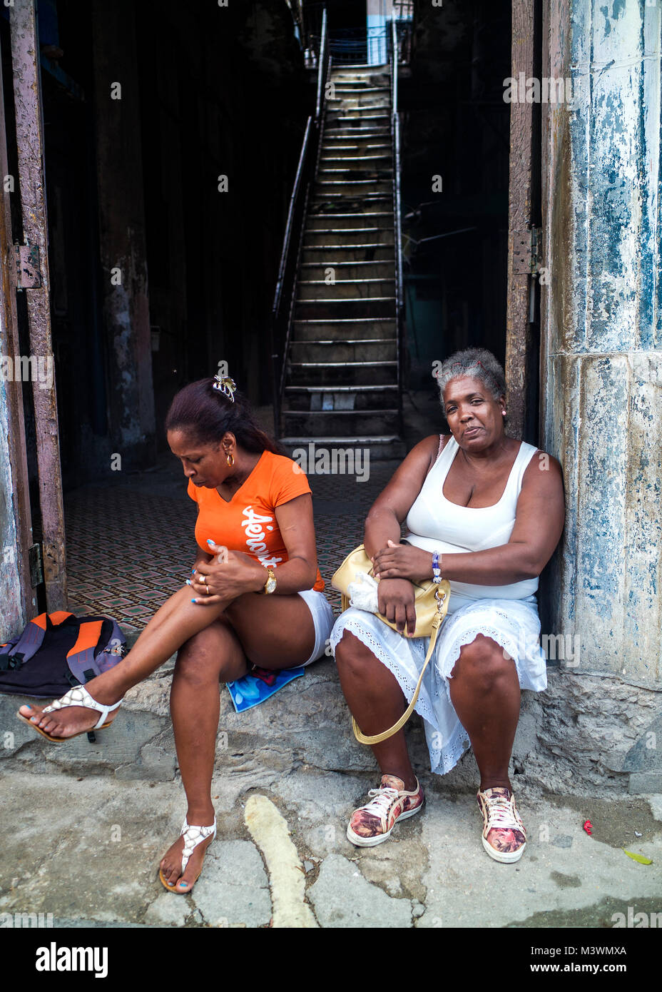 two cuban women sitting on the stoop of a doorway in Havana, Cuba Stock Photo - Alamy
