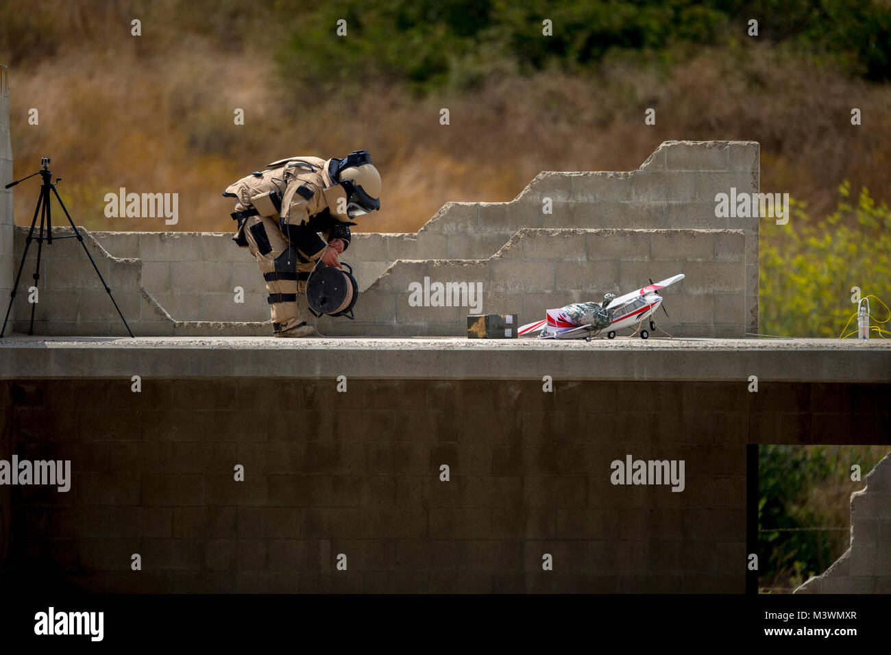 An explosive ordnance disposal operator places a restraining rope on an ...