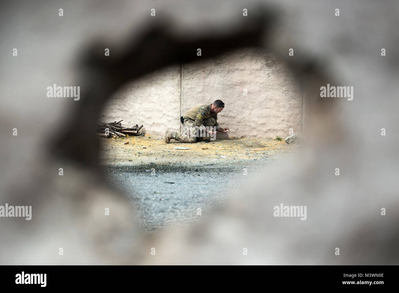 A sniper hole provides a view of U.S. Air Force Staff Sgt. Benjamin ...