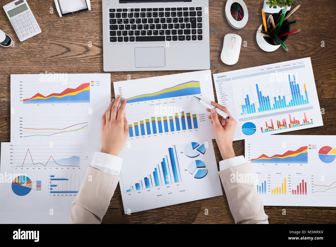 High Angle View Of A Businessperson's Hand Analyzing Graph On Wooden ...