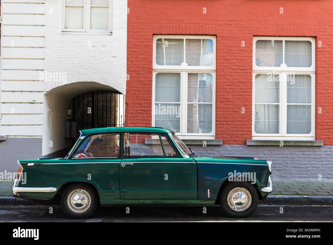 Old vintage car parked on a street in the medieval city of Bruges ...