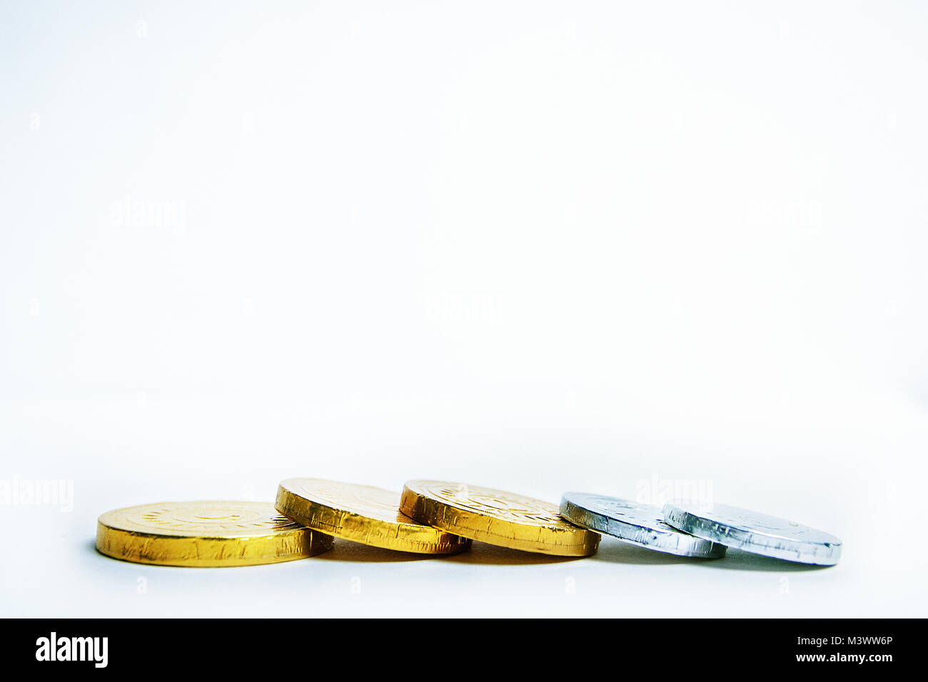 Gold and silver chocolate coins in wrappers Stock Photo - Alamy
