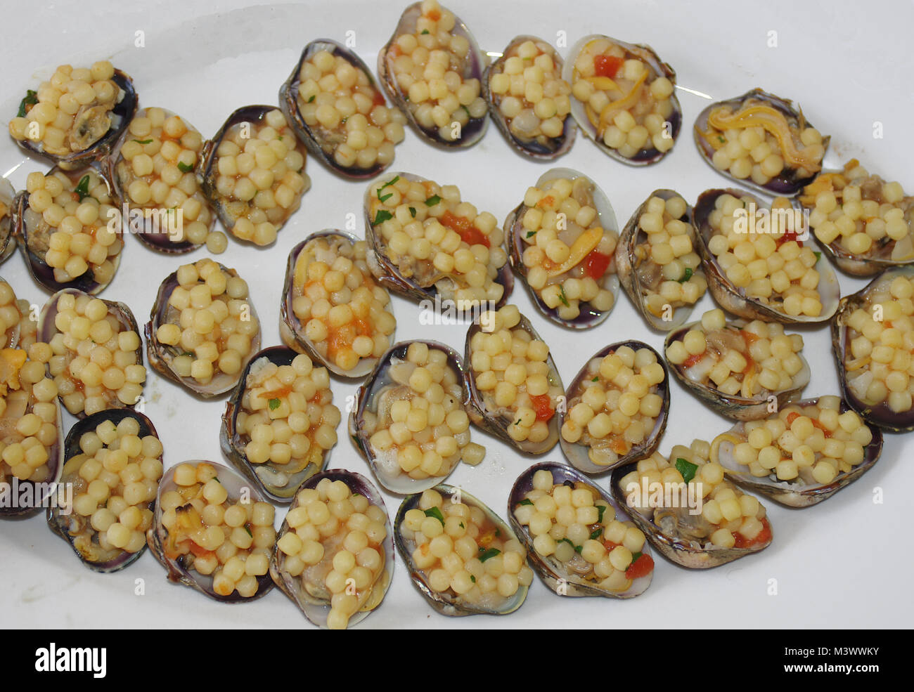 Stuffing clams with "fregula", an typical Sardinian pasta Stock Photo ...