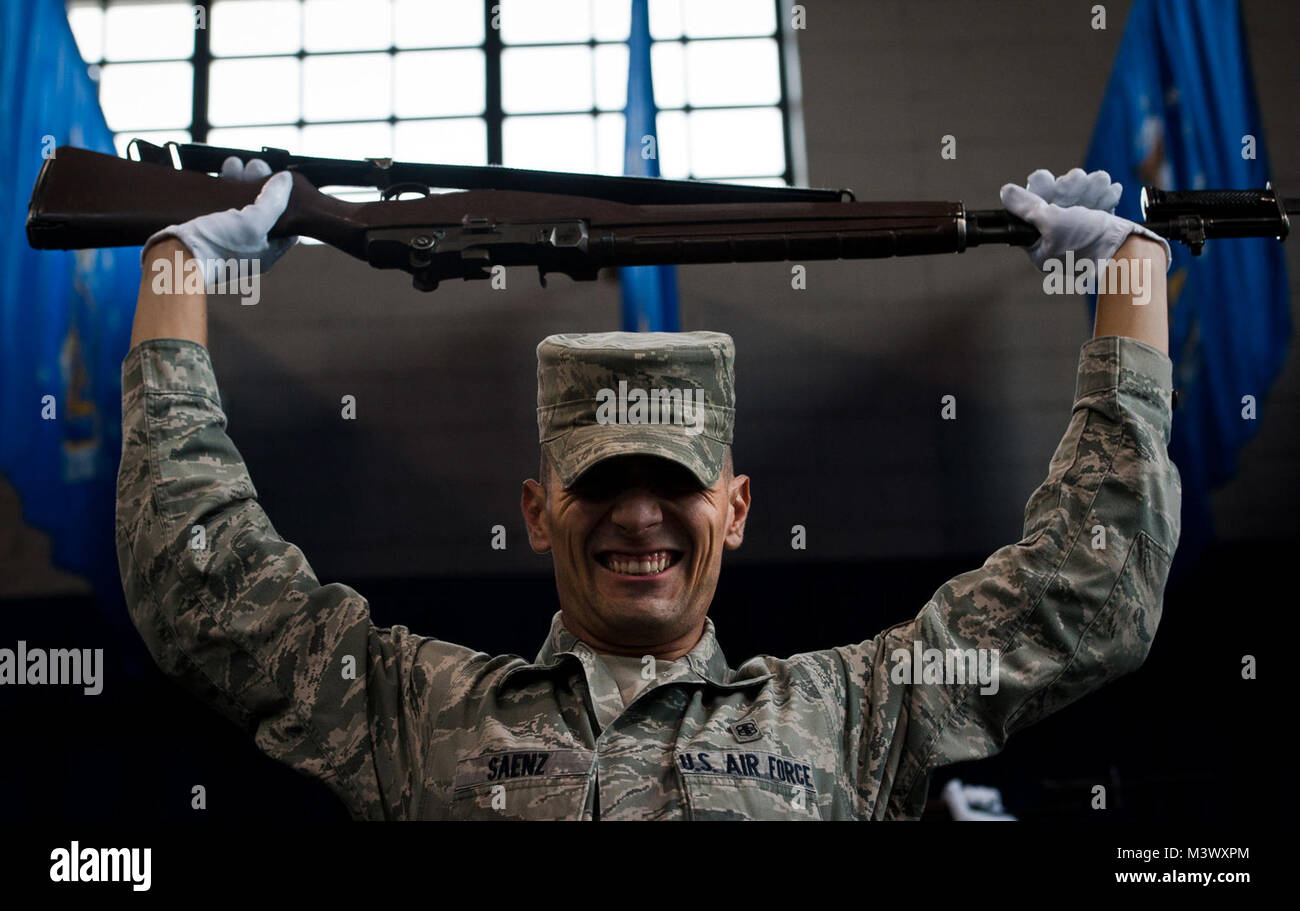 Senior Airman Anthony Saenz pushes his rifle above his head repeatedly ...