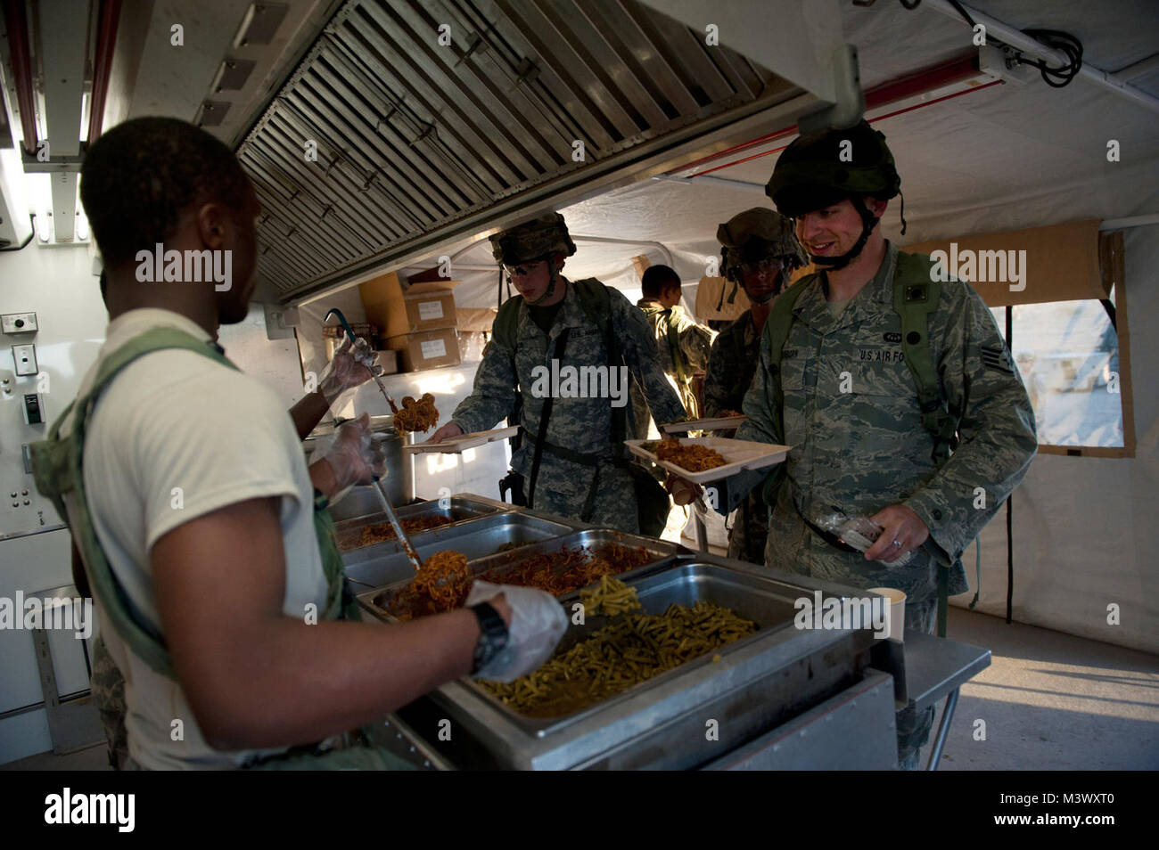 Staff Sgt. Christopher Dearborn (right) is served dinner by a Soldier ...