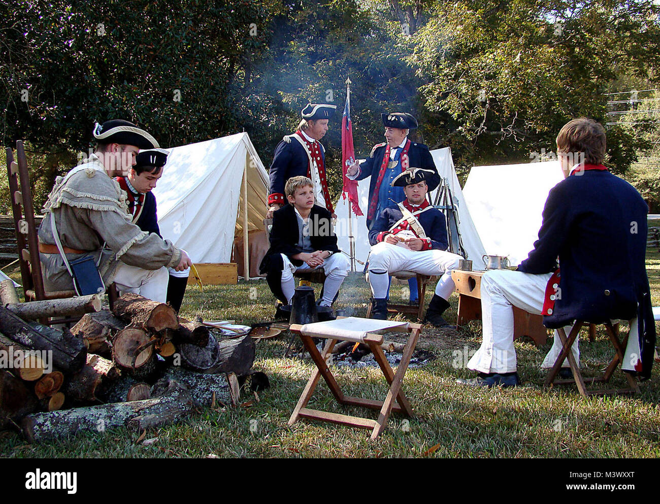 Portraying soldiers of the American colonies, re-enactors relax in ...