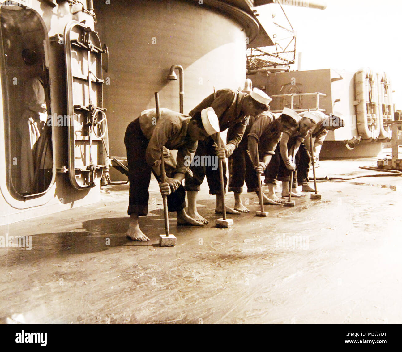 80-G-442192: USS Newport News (CA-148), Second Division Holystoning ...