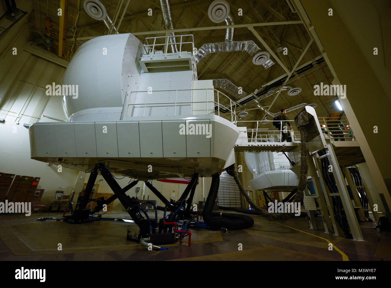 A C-130 student leaves a flight simulator after completing a training sortie. The simulators are ...