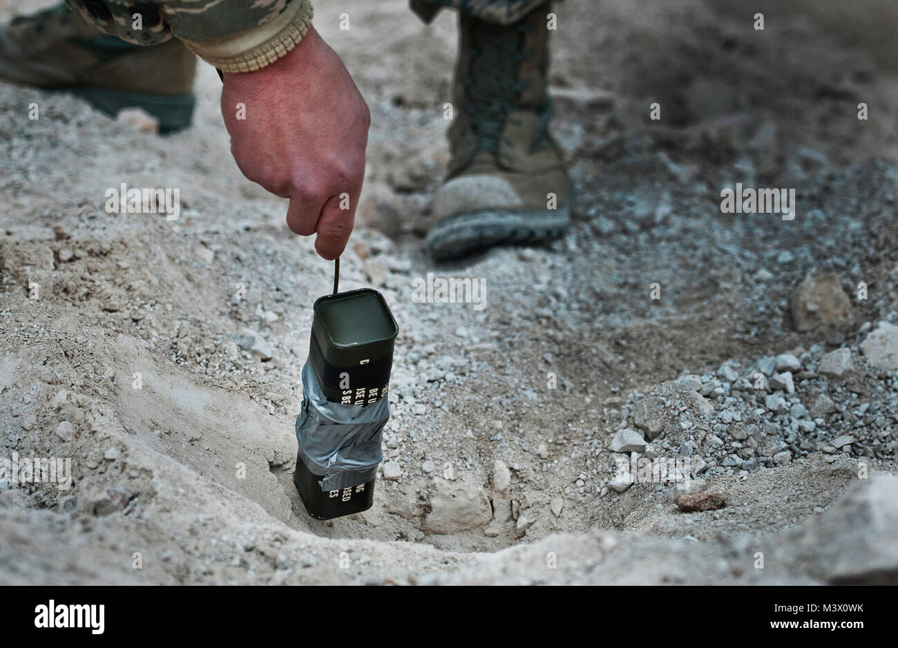 Senior Airman Adam Lorenz lowers a brick of ANFO, an explosive mixture ...