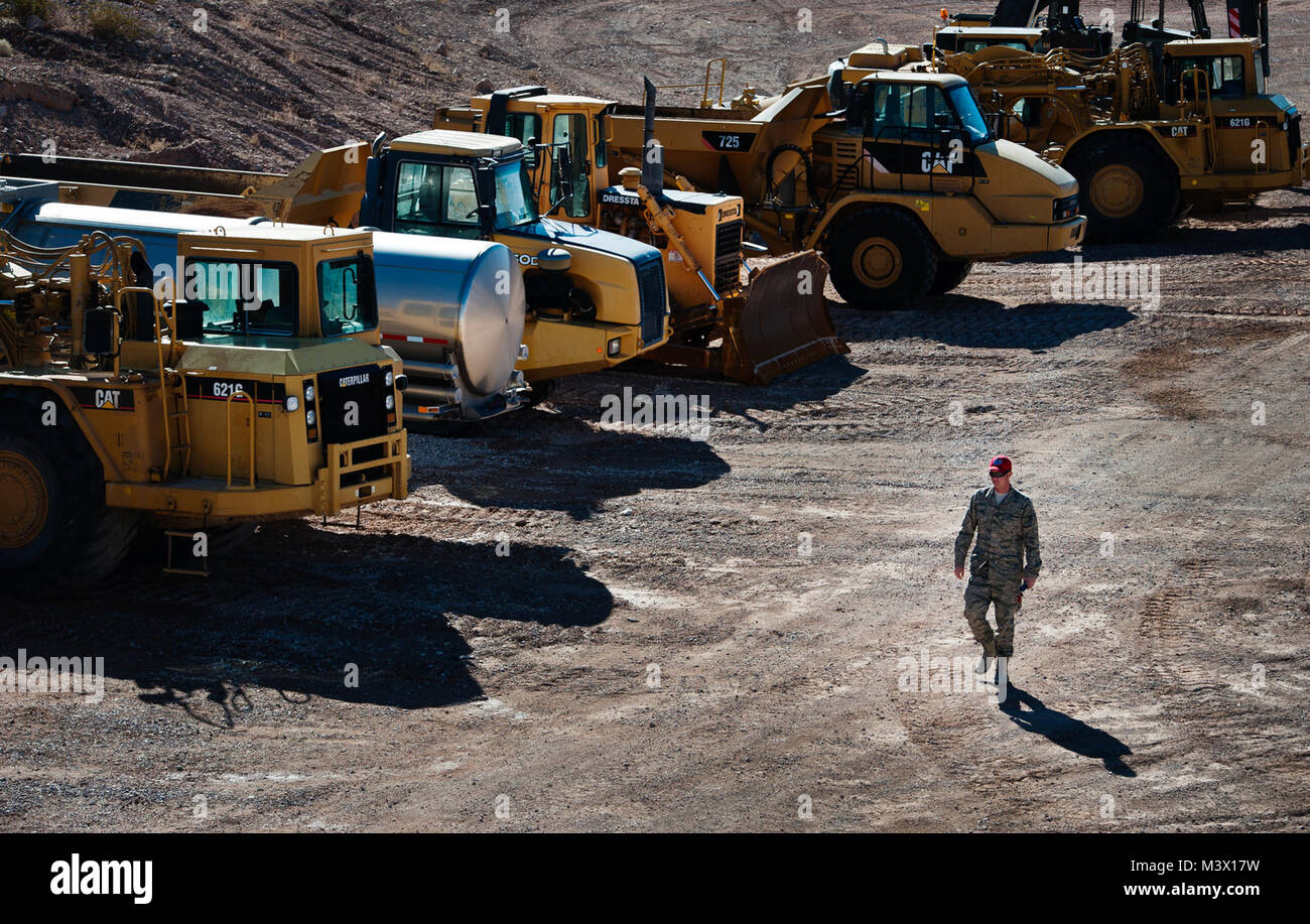 Senior Airman David Calkins walks past a row of heavy equipment ...
