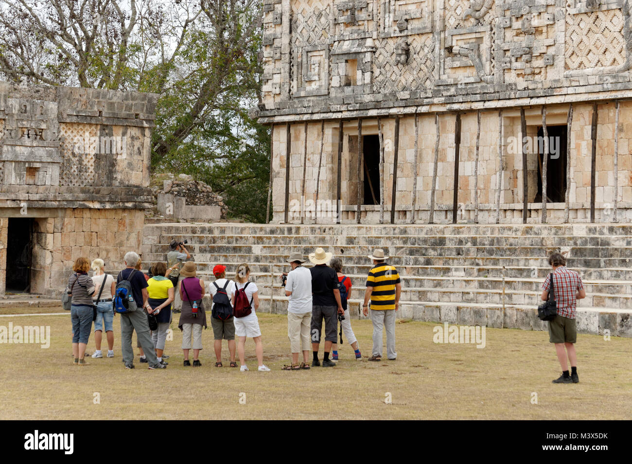 Group of tourists in the Nunnery Quadrangle at the Mayan ruins of Uxmal ...
