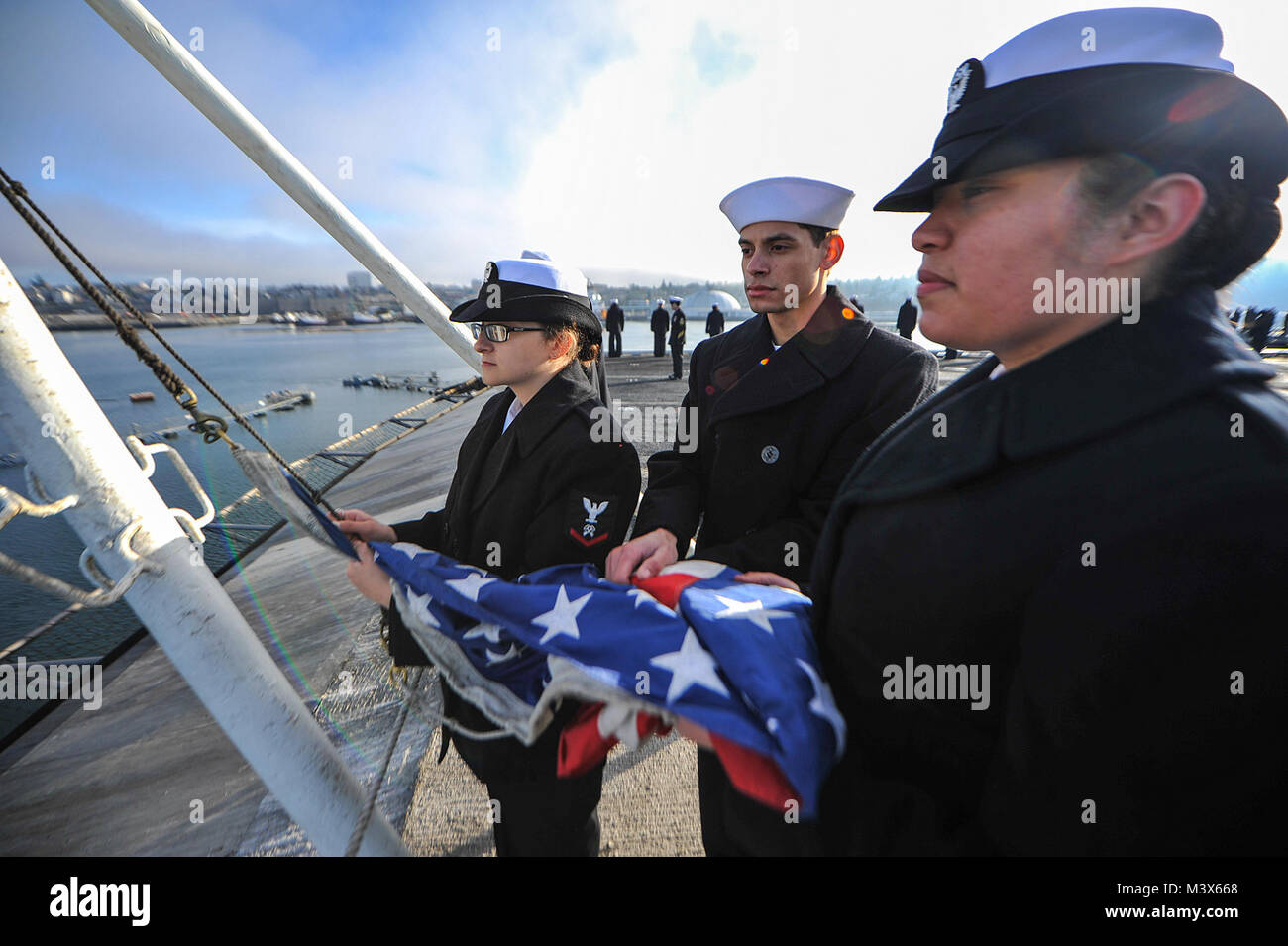 EVERETT, Wash. (Dec. 16, 2013) Sailors prepare to raise the flag as the ...