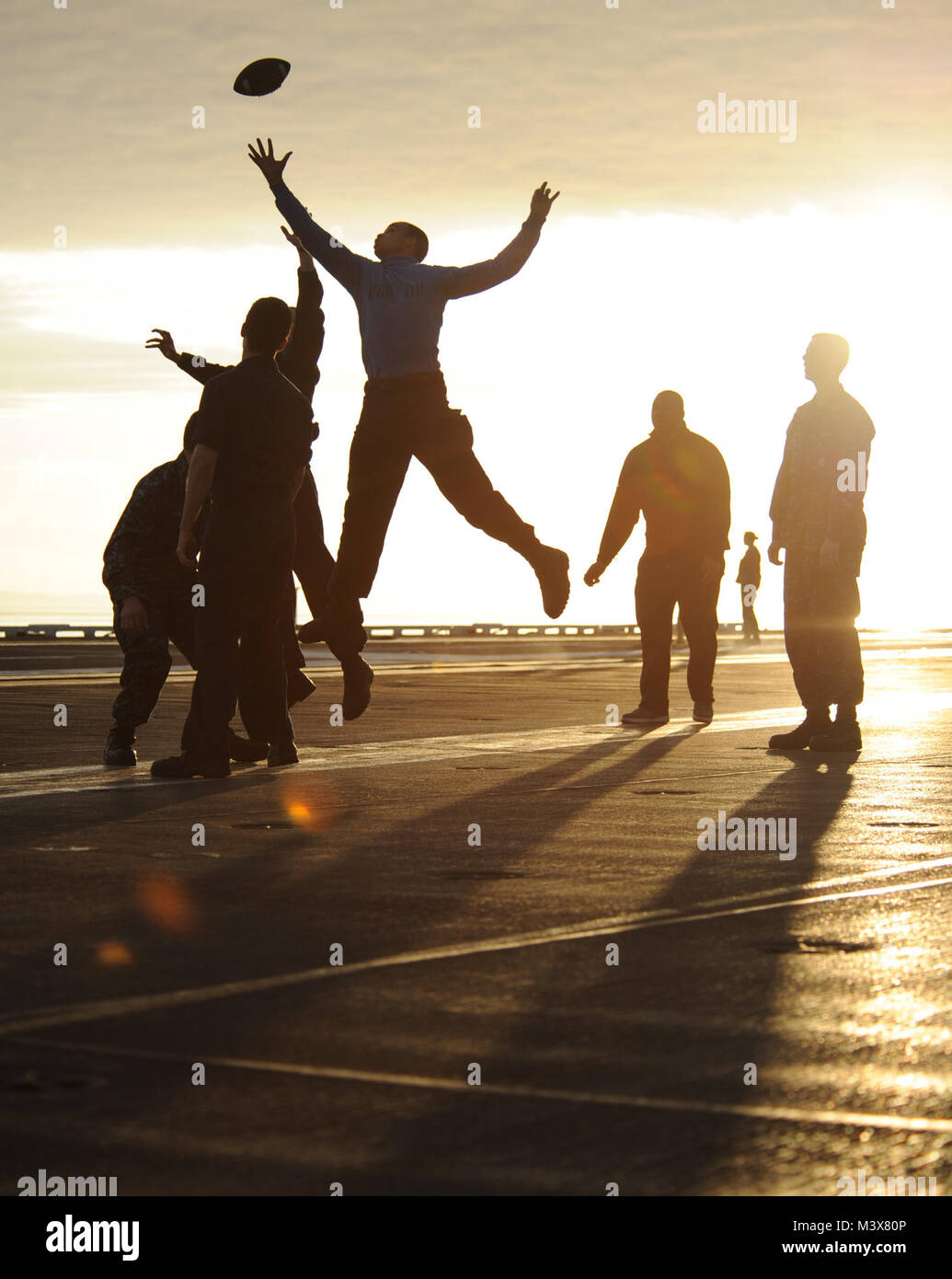 SALISH SEA (June 16, 2014) Sailors play football on the flight deck of ...