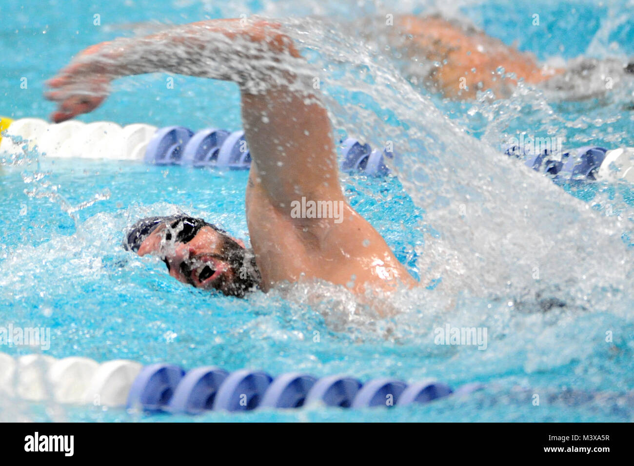 Navy team’s Petty Officer 3rd Class Red Ramos swims the 100 meter ...