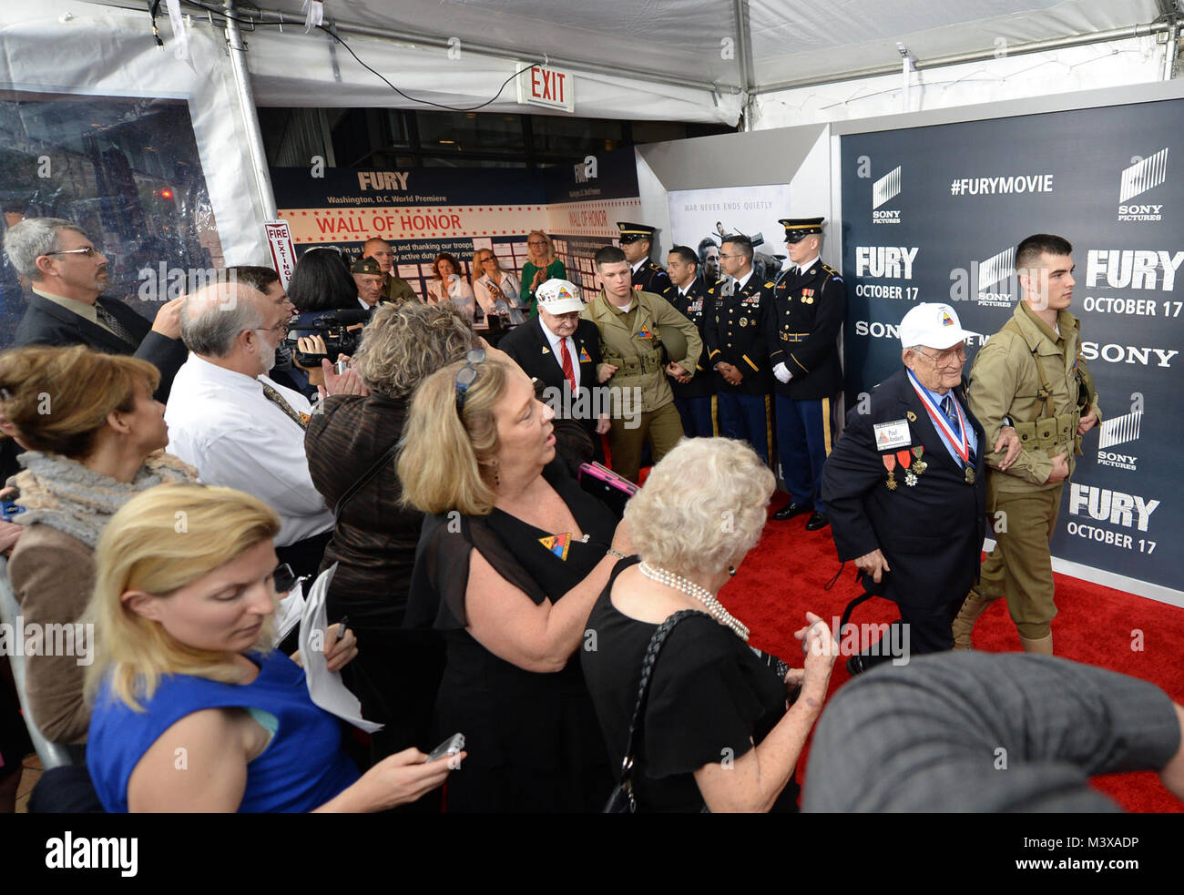 Retired World War II veterans are escorted down the red carpet by ...