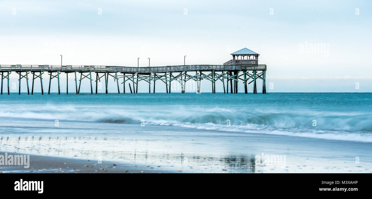 Sunrise with the Atlantic Beach pier in the background with sand, ocean ...