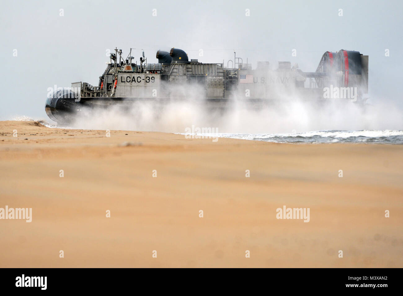 A U.S. Navy LCAC (Landing Craft Air Cushioned) arrives at a beach ...