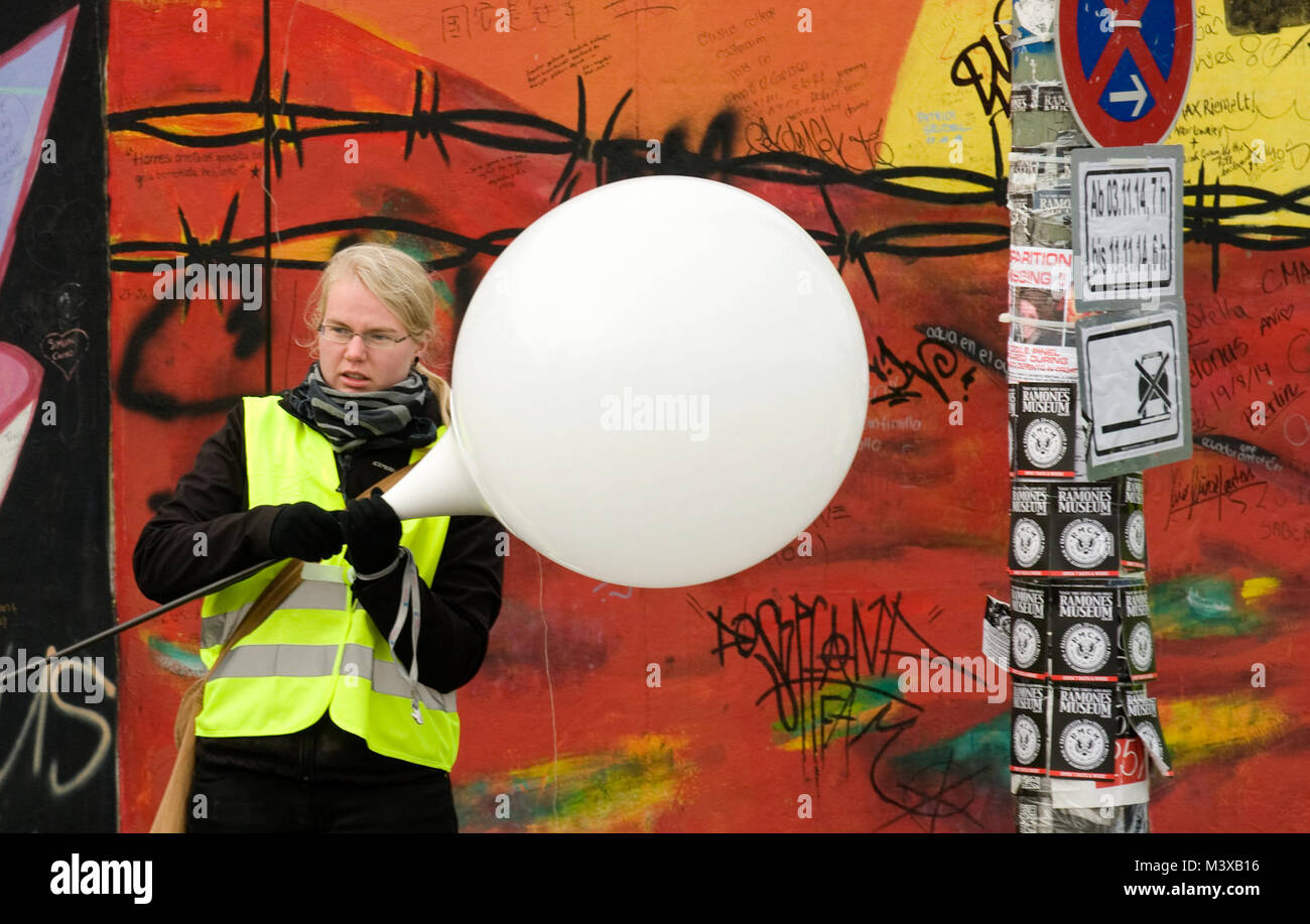 A Berliner sets up the illuminated balloons along the “East Side ...