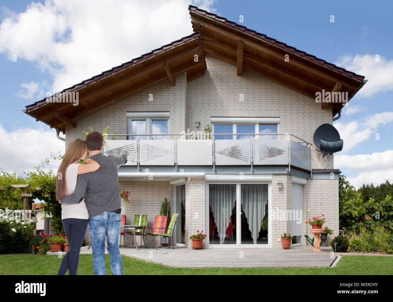 Rear View Of A Young Couple Pointing At New House Stock Photo - Alamy