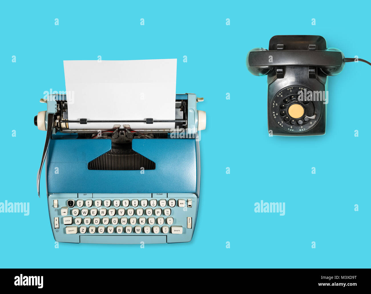 Old electric typewriter and phone on plain background Stock Photo - Alamy
