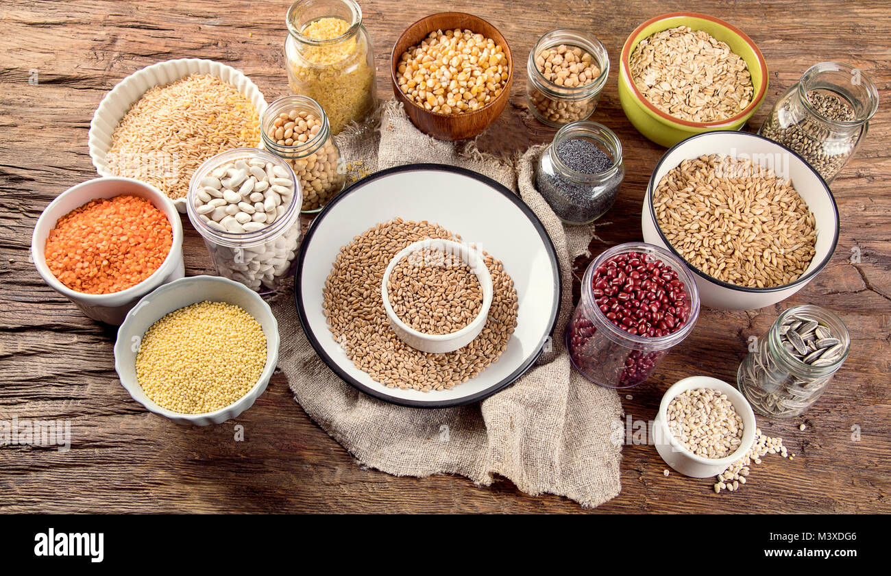 Ancient grains, seeds, beans on wooden background. Top view Stock Photo ...