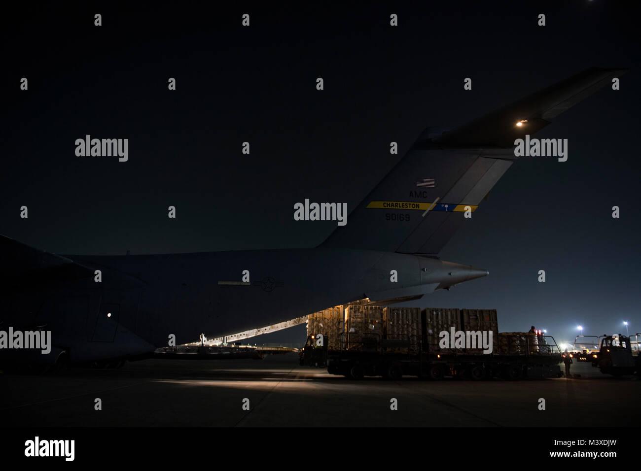 Aerial transportation team personnel work to unload cargo from a U.S ...