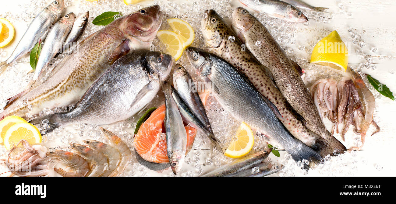 Fresh fish and seafood on white wooden background. Healthy eating. Top ...