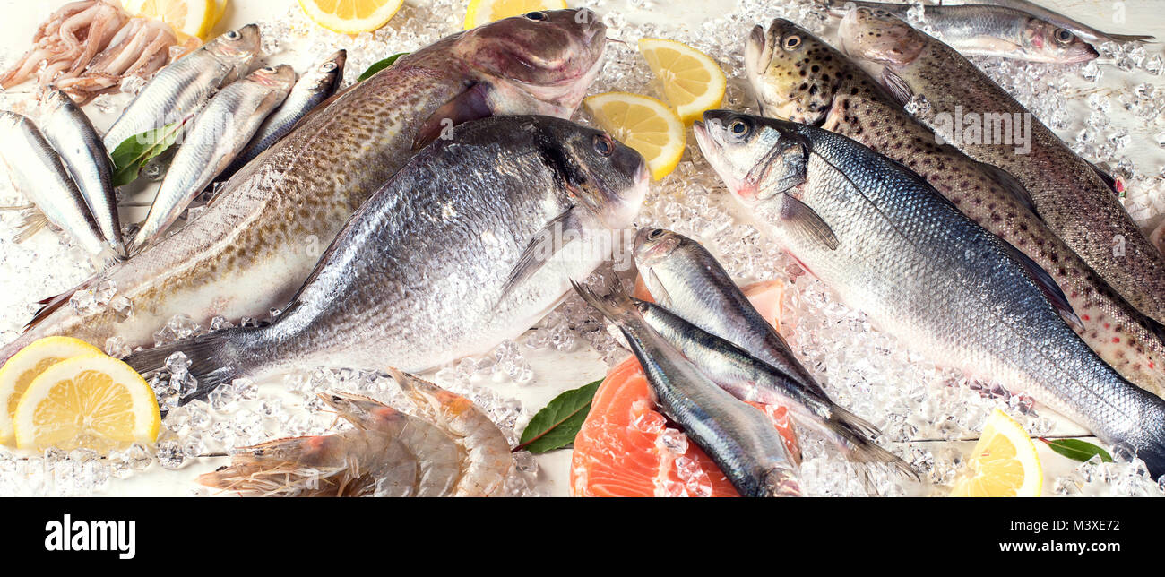 Fresh fish and seafood on white wooden background. Healthy eating. Top ...