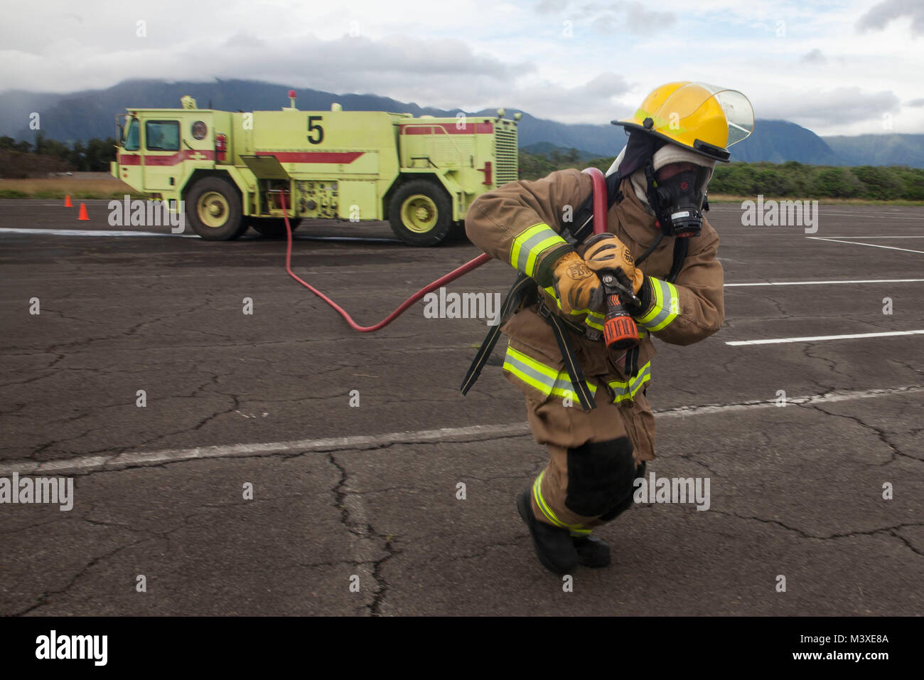 A U.S. Marine with Aircraft Rescue Fire Fighting (ARFF) unrolls a ...