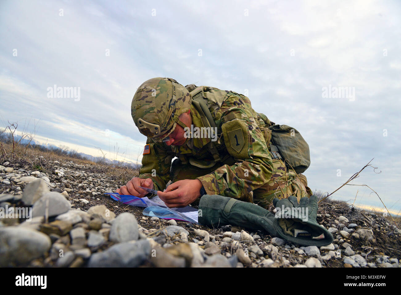 A U.S. Army Soldier plots a point on a map for a land navigation event ...